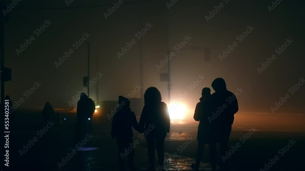 Human silhouettes moving by the dark city streets during blackout ...