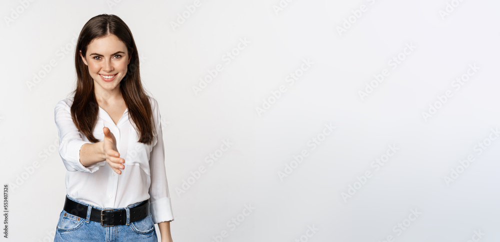 Smiling, friendly corporate woman extending arm for handshake, shaking ...