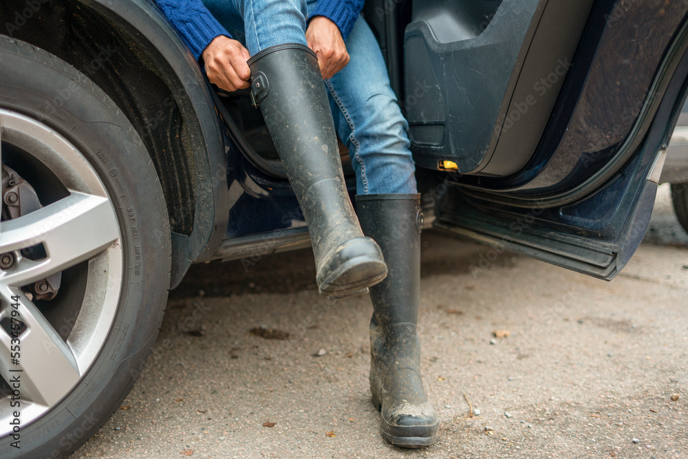 Man sitting on back seat and putting on rubber boot Stock Photo | Adobe ...