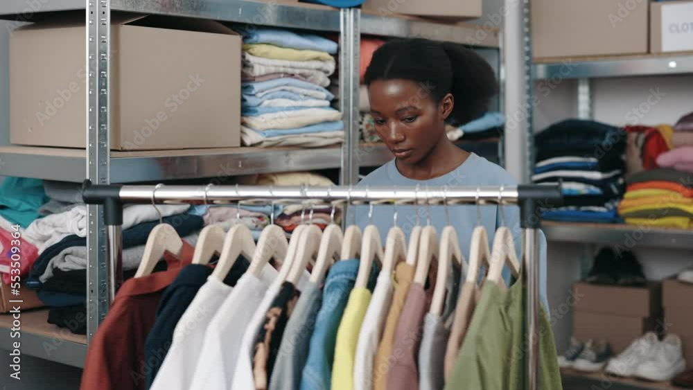 Multiracial brunette woman working with clothes for recycle while ...