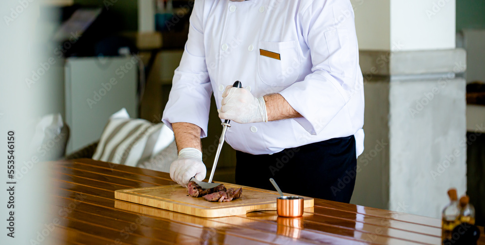 Hand man cutting meat steak,Slicing juicy beef steak by knife in chef ...