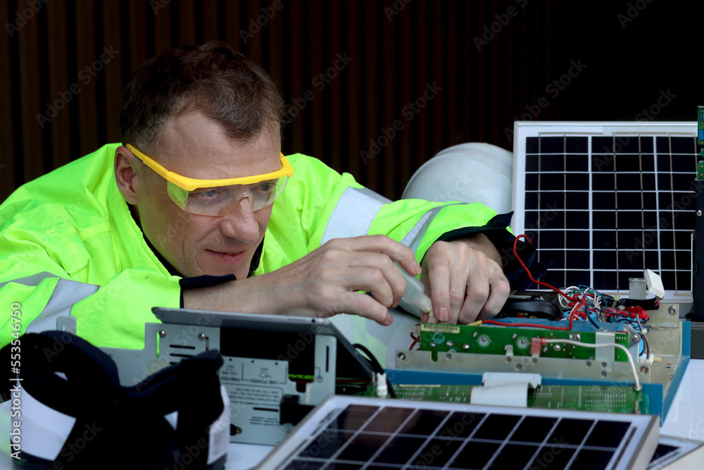Electrical engineers working with electronic circuit board and solar ...