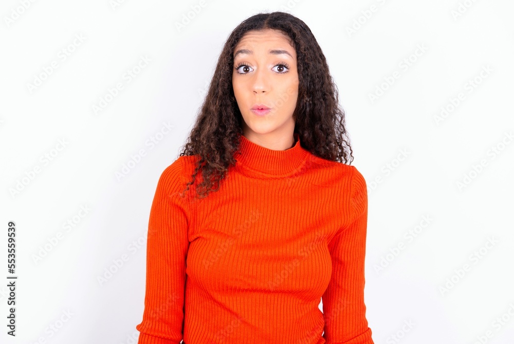 teen girl wearing knitted red sweater over white background expressing ...