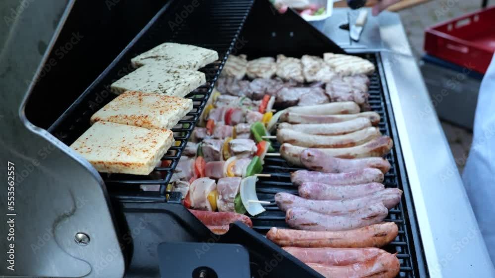 BBQ Close-up shot. Different types of steaks and sausages on a big ...