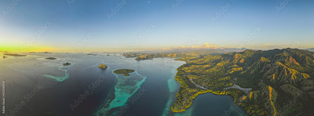 Aerial view of the Komodo Islands with bright yellow sunlight on the ...
