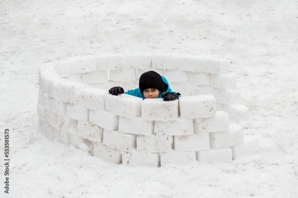 A Young Boy Hides Behind A Wall Of Snow Blocks At A Mountain Resort ...