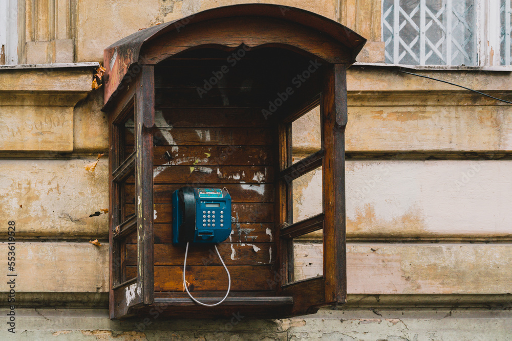 Old wooden empty public telephone booth mounted on the facade of the ...
