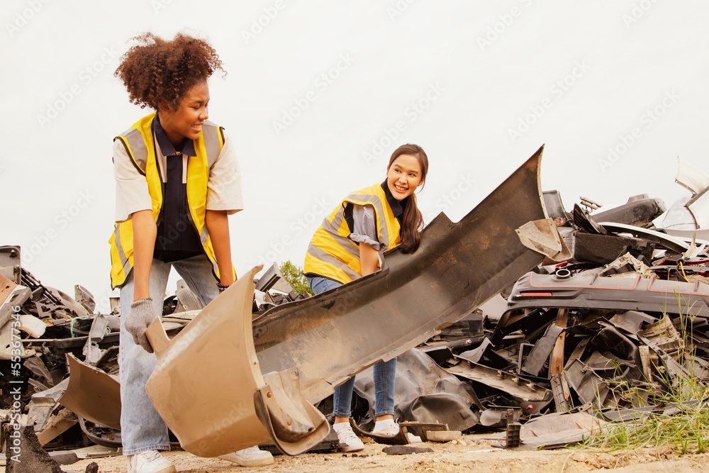 Two cheerful female workers working in an outdoor warehouse collecting ...