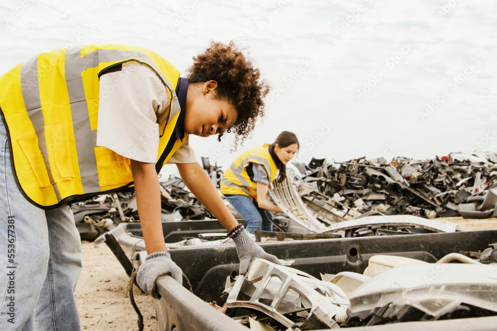 Two female workers working in an outdoor warehouse factory collecting ...