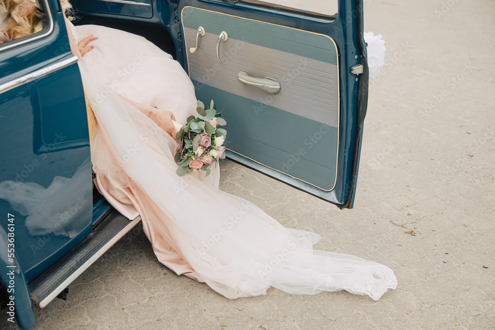 Beautiful wedding dress and bridal bouquet. Bride gets into the wedding ...