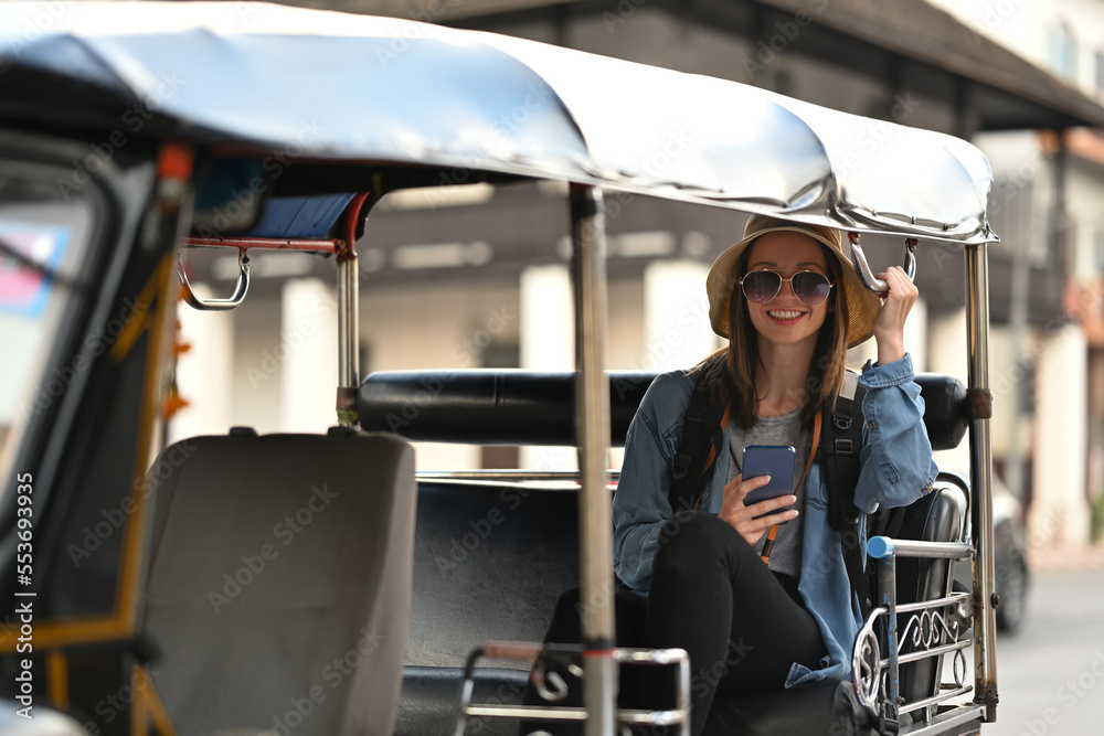 Caucasian woman tourist with sunglasses sitting in back seat of Tuk Tuk ...
