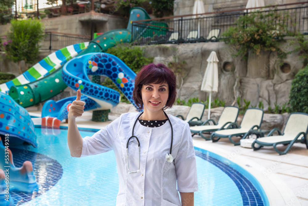 Nurse water park worker shows class with hand gesture while standing at ...