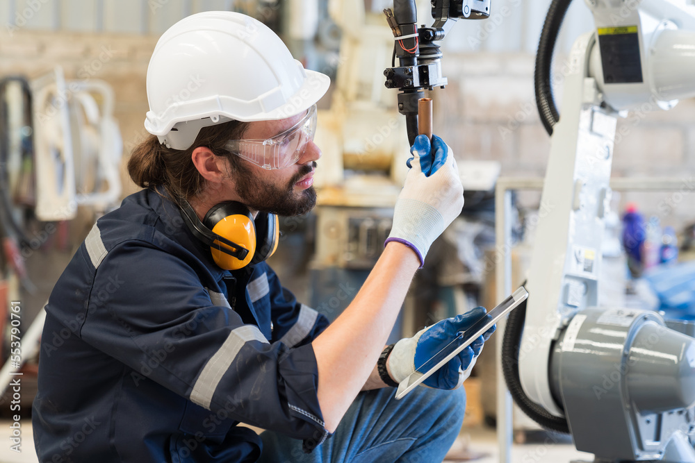 Male engineers worker holding digital tablet working with welding robot ...