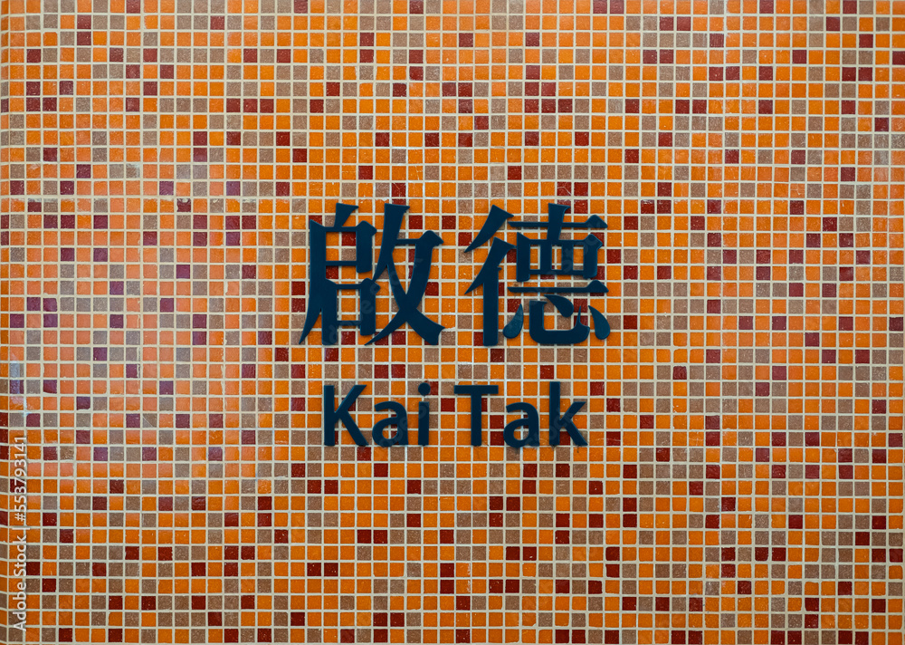 Station name sign in Chinese and English with orange colored wall in ...