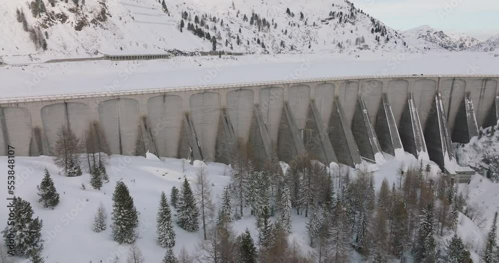 Concrete Dam seen from above, aerial of snow covered lake and dam wall ...