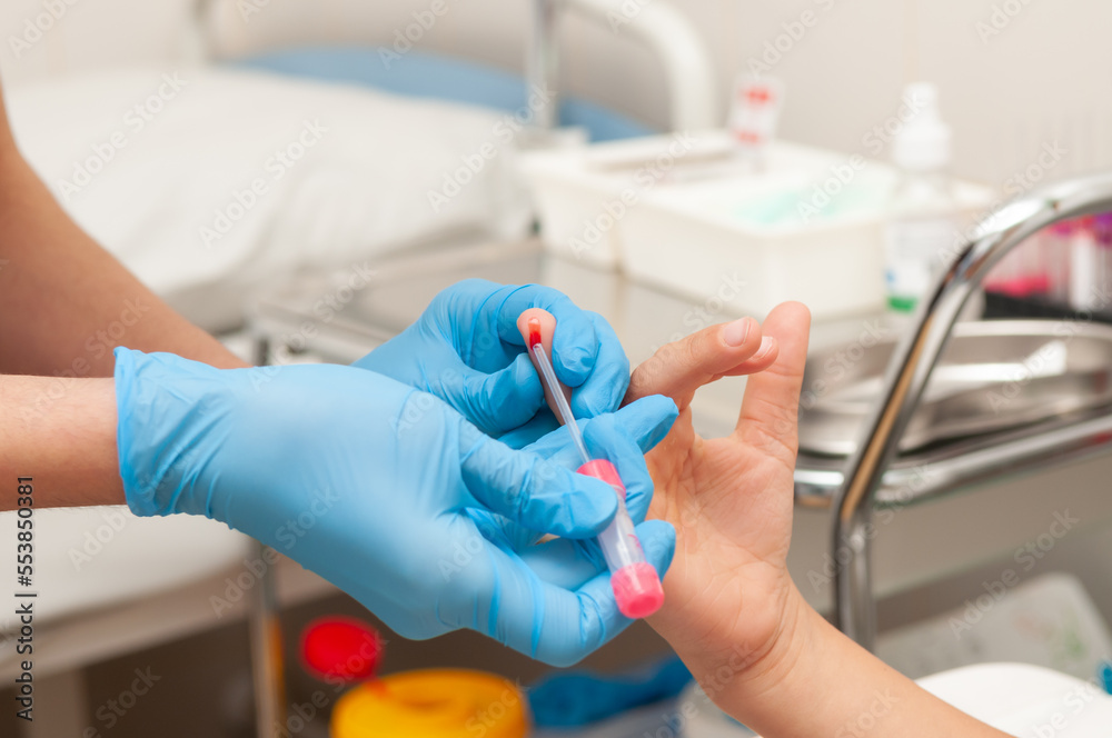 Close-up blood test from a child's finger. Doctor takes blood from a ...