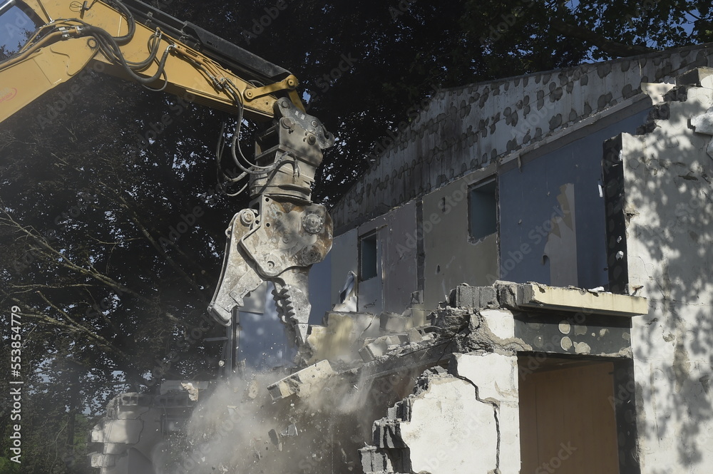 sur un chantier de démolition d'immeuble une grosse pince hydraulique ...