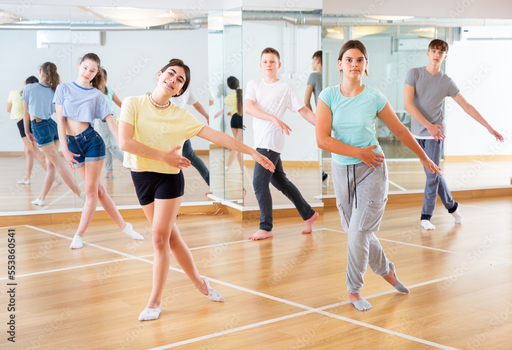 Positive teenage dancers doing dance workout during group class Stock ...