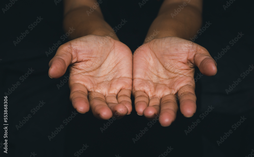 Woman with open hands praying for God's blessing in black background ...