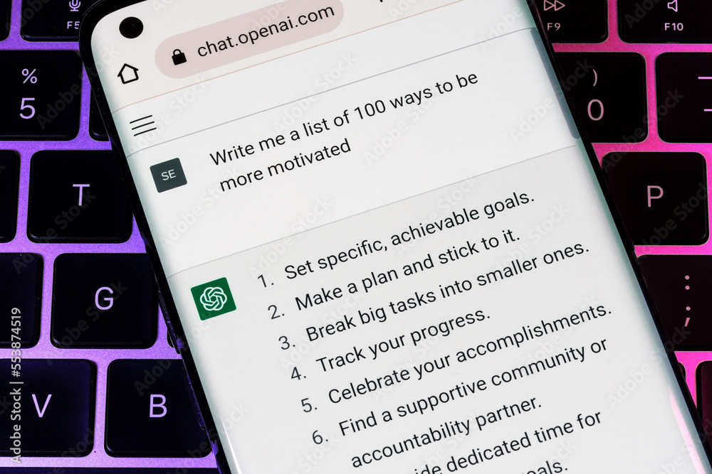 OPEN AI ChatGPT chat bot seen on smartphone placed on laptop. AI ...