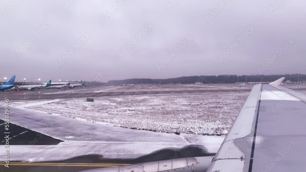 view from window on airplane turbine of plane travels along runway ...
