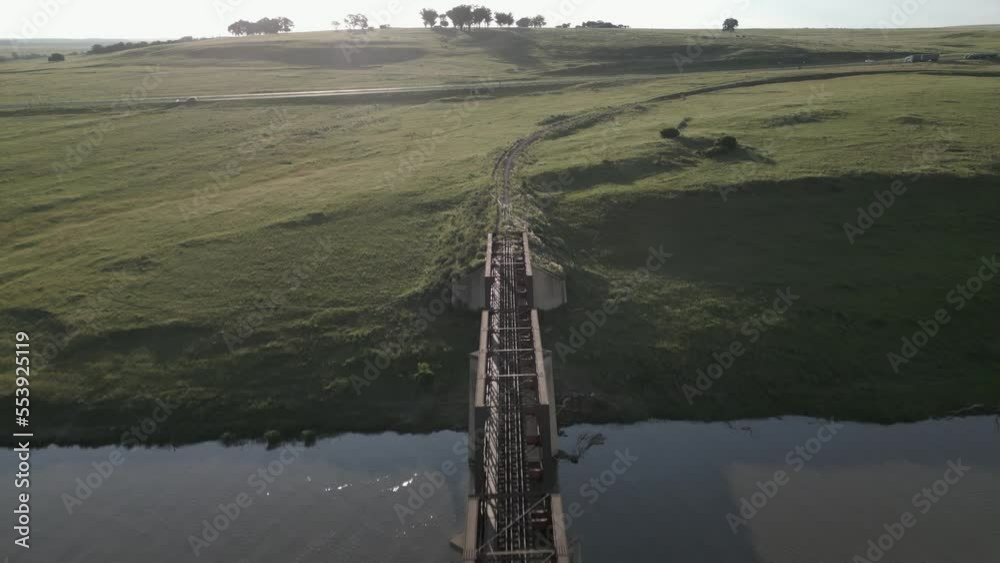 Flyover of decommissioned railway bridge with highway traffic beyond ...