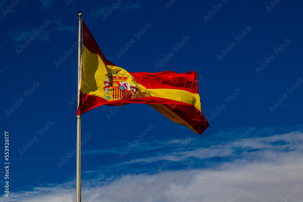 flag of spain red yellow on blue sky background with white clouds Stock ...