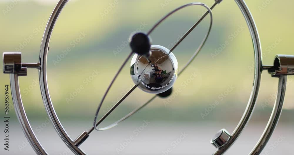 Cropped view rotating table pendulum balls anti stress in the tropical nature background at the ...
