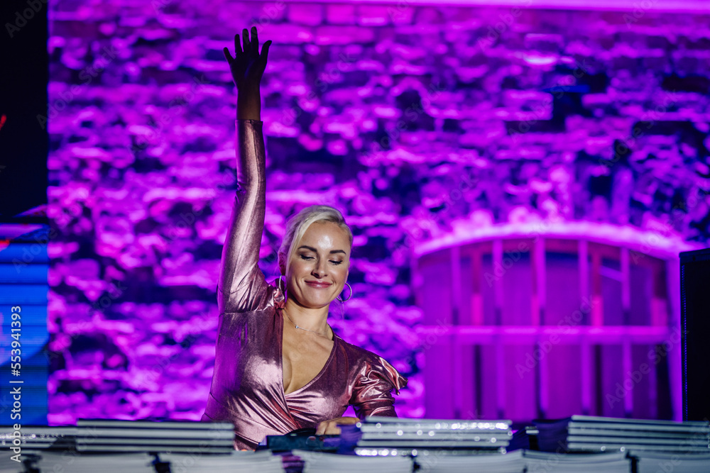 European female disc jockey working at controller, professional dj ...