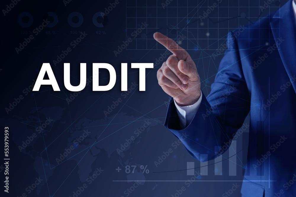 Audit concept. Businessman pointing at graph on dark blue background ...