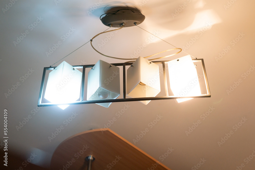 Four lamps of cheap light installed on the ceiling in the room. Bedroom ...