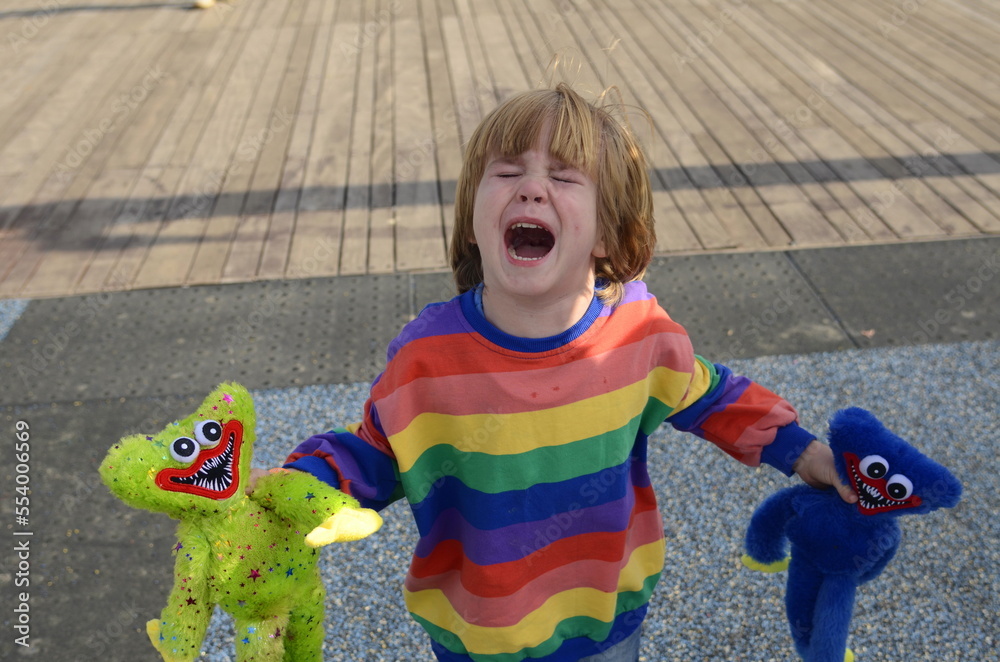 Little boy hysterical. Child whim. Soft toys Huggy Wuggy, violent ...