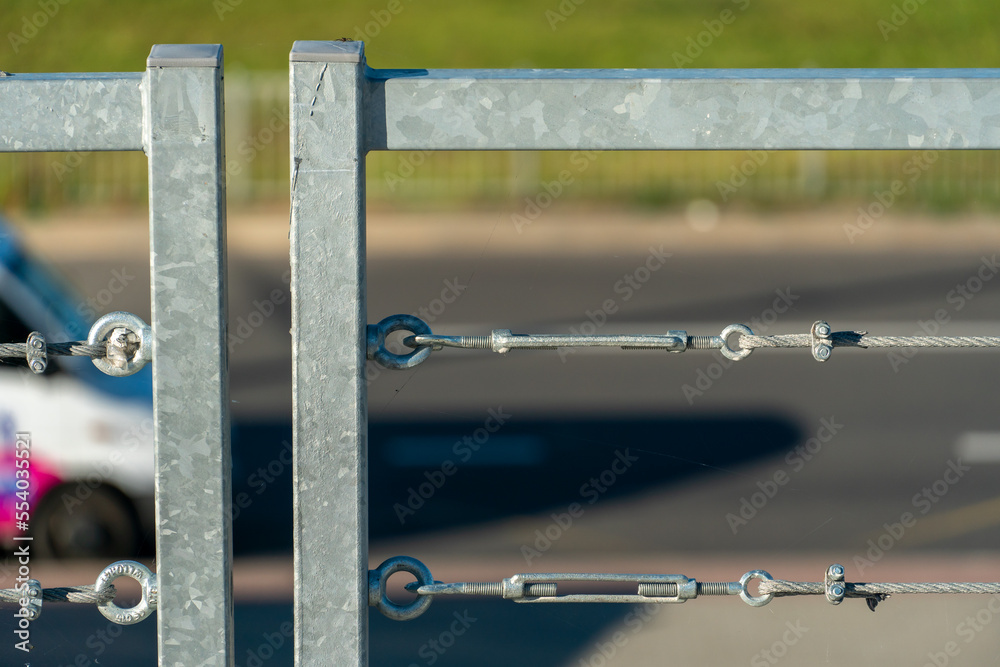 Modern metal fence made of metal profiles and cables. Connection and ...