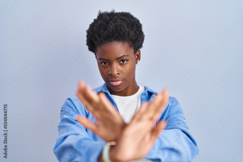 African american woman standing over blue background rejection ...