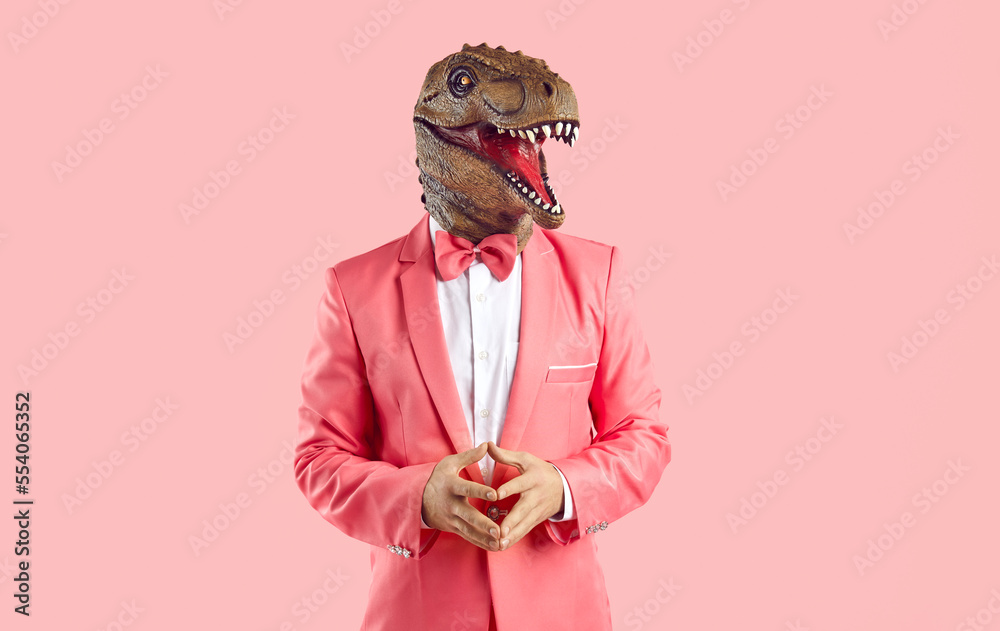 Portrait of a funny bizarre man wearing a goofy rubber dinosaur mask ...