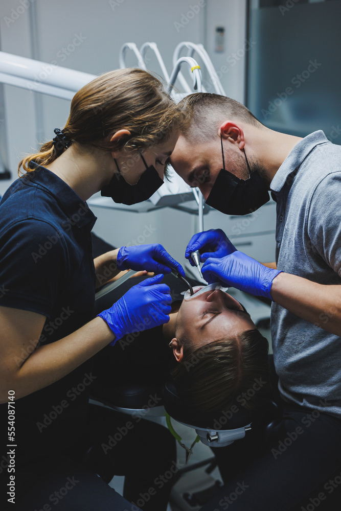 Orthodontic treatment of teeth. The doctor installs metal braces on the ...