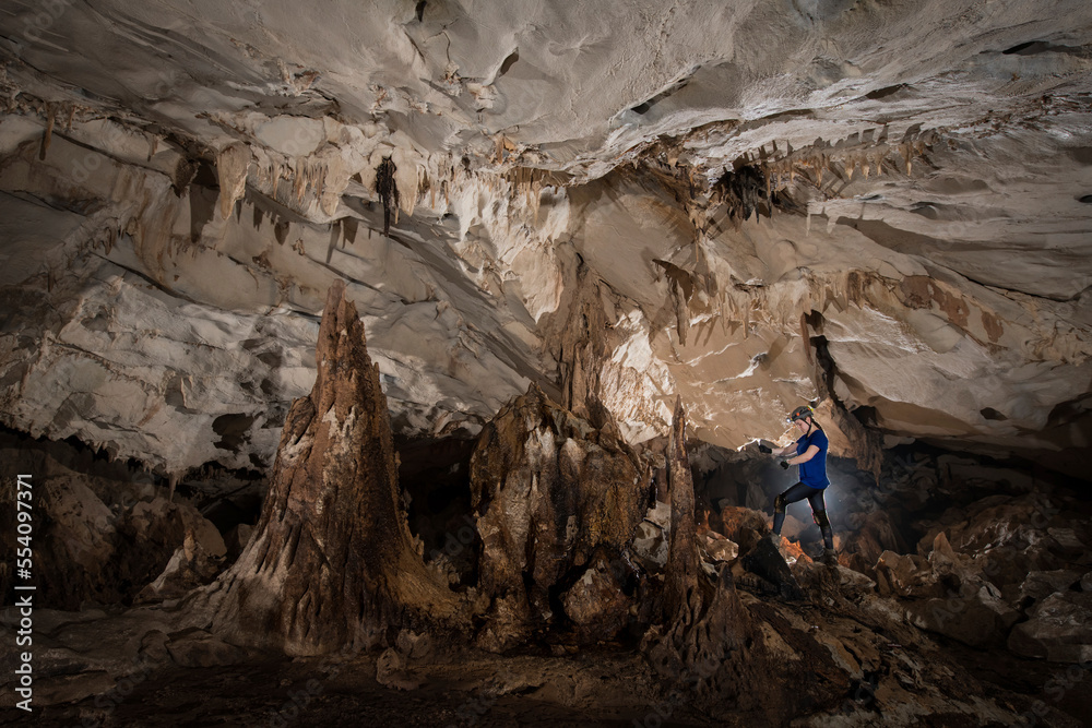 Researcher exploring stalagmites in a cave in Gunung Mulu National Park ...