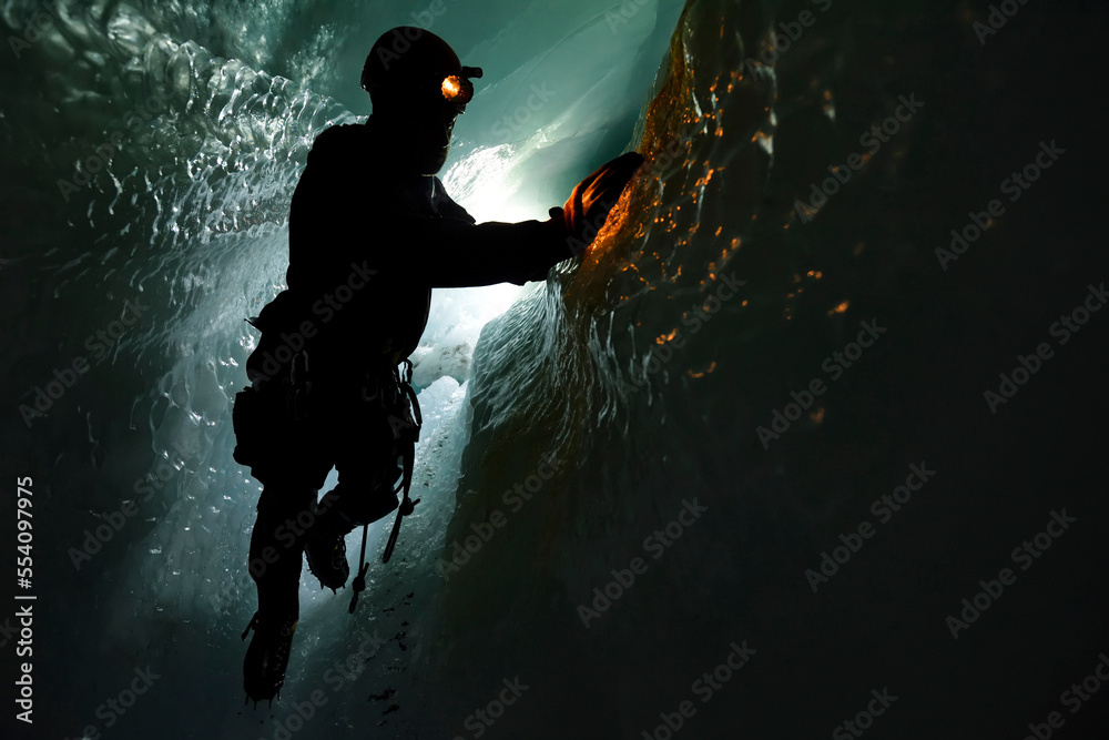 A cave explorer and glaciologist traverses through a tunnel below the ...