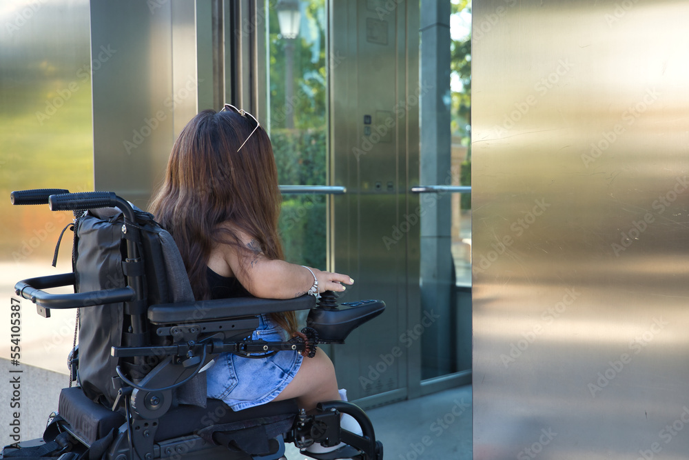 Disabled woman with reduced mobility and small stature in an electric ...