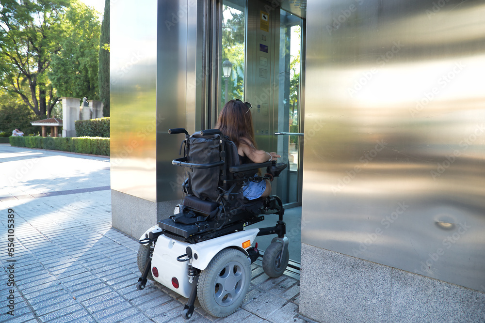 Disabled woman with reduced mobility and small stature in an electric ...
