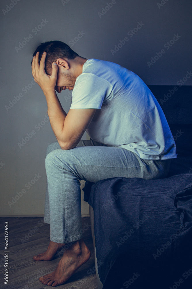 Depressed man sitting on the floor with his head down and leaning ...
