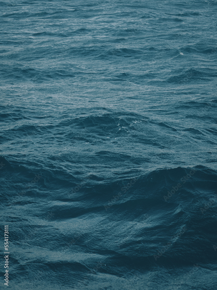 Dark blue-green color of water surface with waves in middle of endless ...