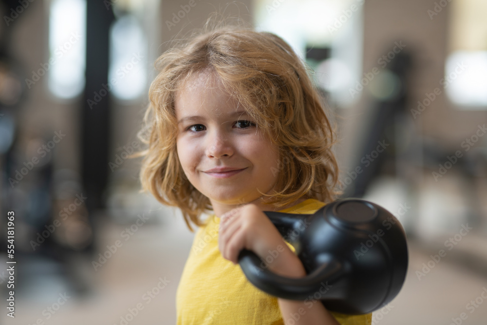 Kid workout kid in gym. Kid raising a kettlebell. Cute child training ...