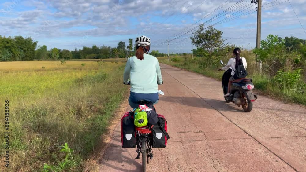 A stationary panning footage of a commuting woman riding her bike with ...