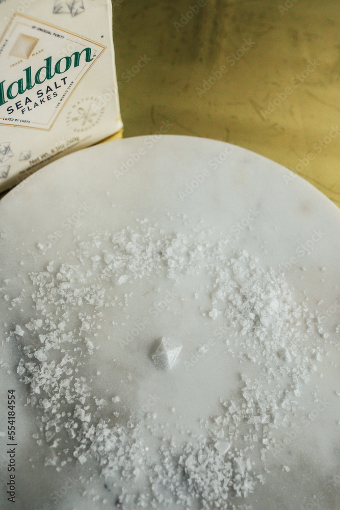 Maldon salt flakes with single pyramid shape salt crystal on white ...