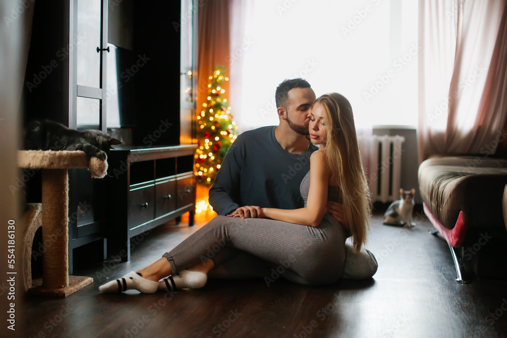 Man and woman hug and kiss at home. Young woman with long hair and big ...