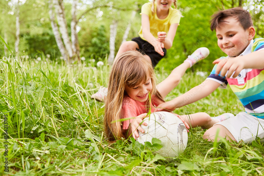 Friends playing football during summer holiday Stock Photo | Adobe Stock