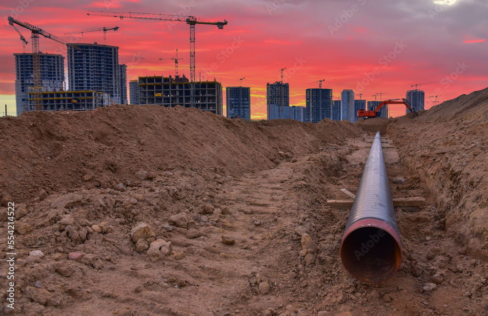 Sewer pipes laying. Sanitary drainage, external sewage. Tower crane on ...