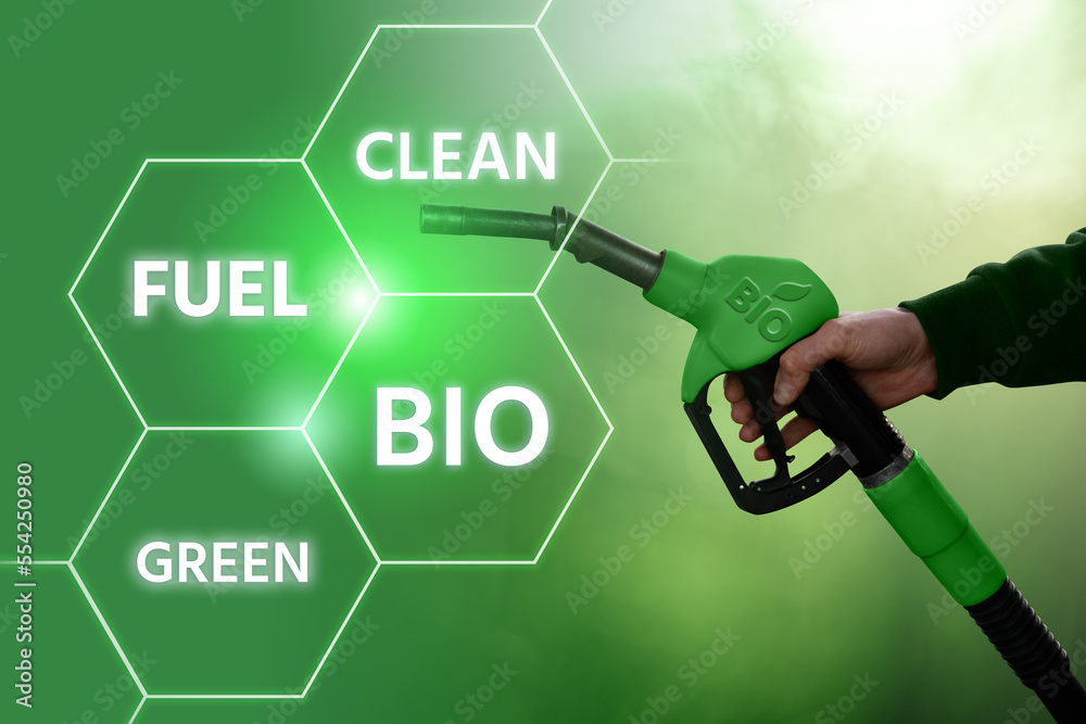 Hand with fuel nozzle with inscription BIO. Carbon neutral bio fuel ...