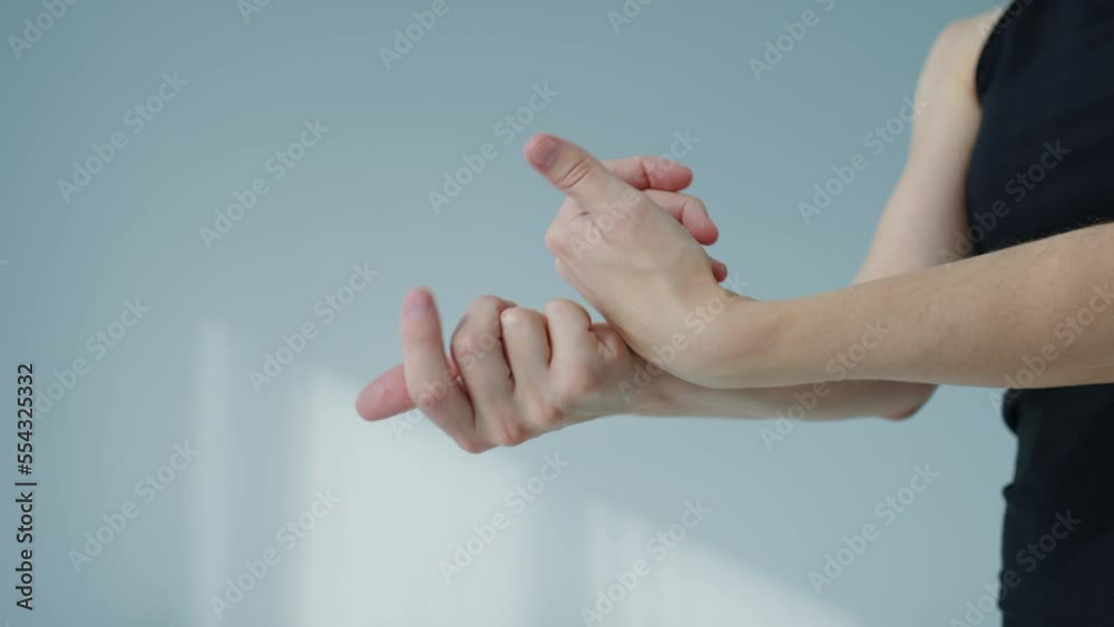 Faceless flexible dancer stretches her arms, twists wrists, flexes and ...